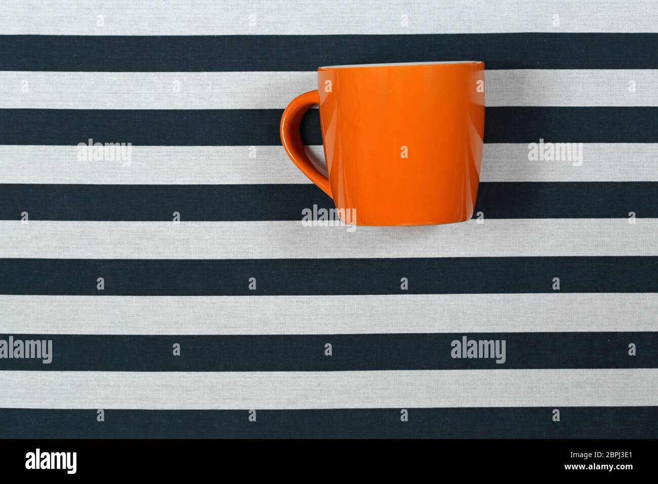 Big Orange Ceramic Mug at Striped Background Stock Photo - Alamy