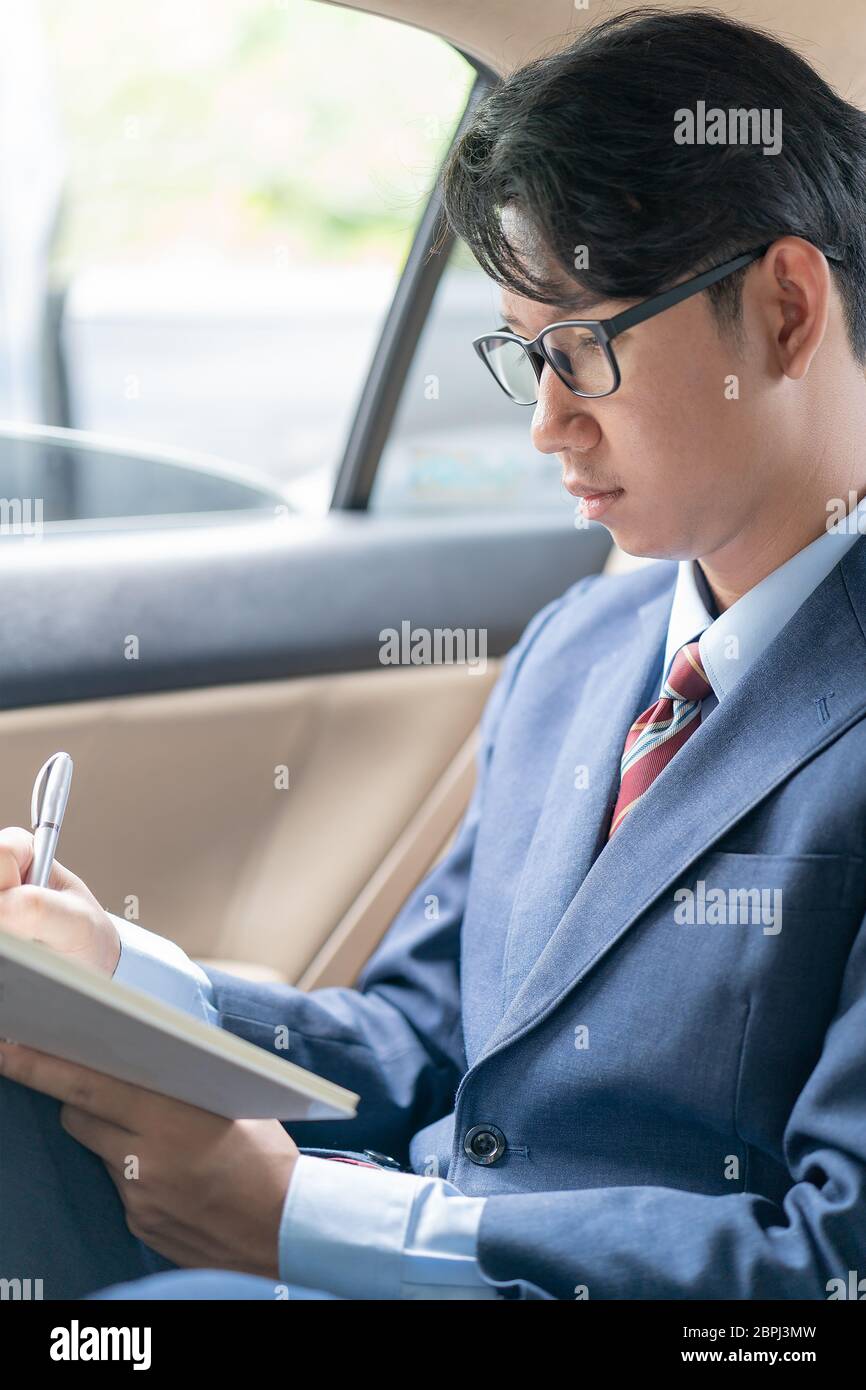 Young asian business men portrait in suit working in the backseat of a ...