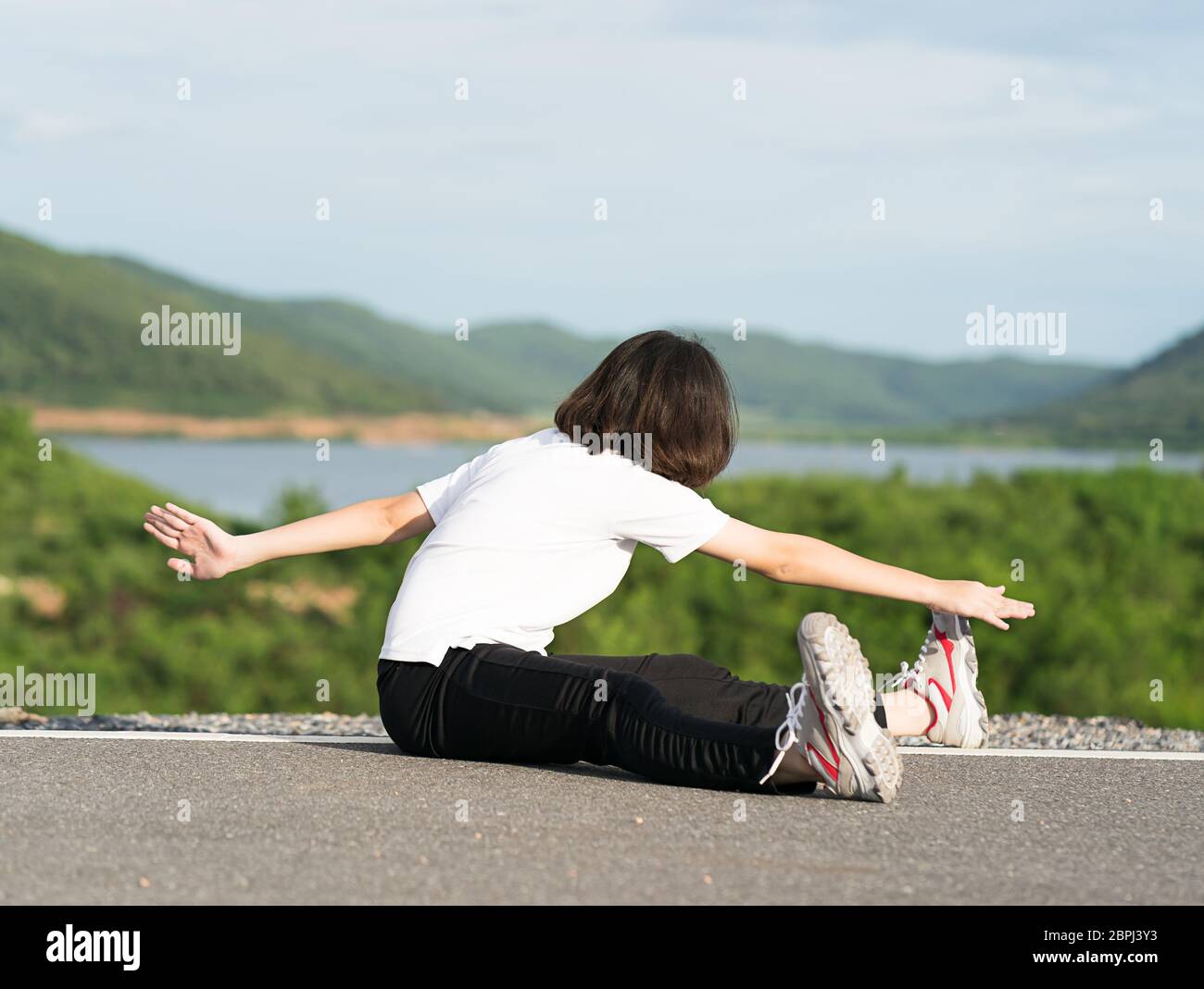 Woman runner doing exercises and warm up preparing for jogging outdoor ...