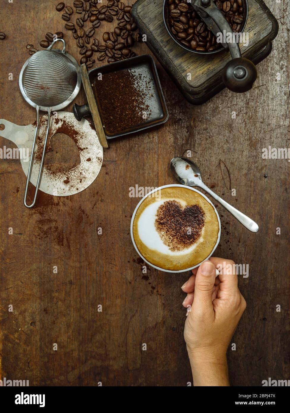 Photo of a messy rustic wooden table of coffee beans, grinder and a ...