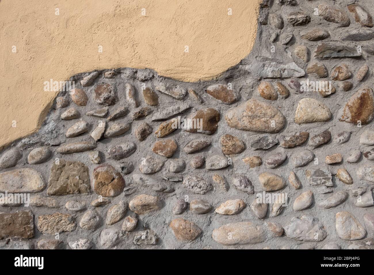 Rustic stone wall partly decorated by plaster. Space for text. Ideal ...