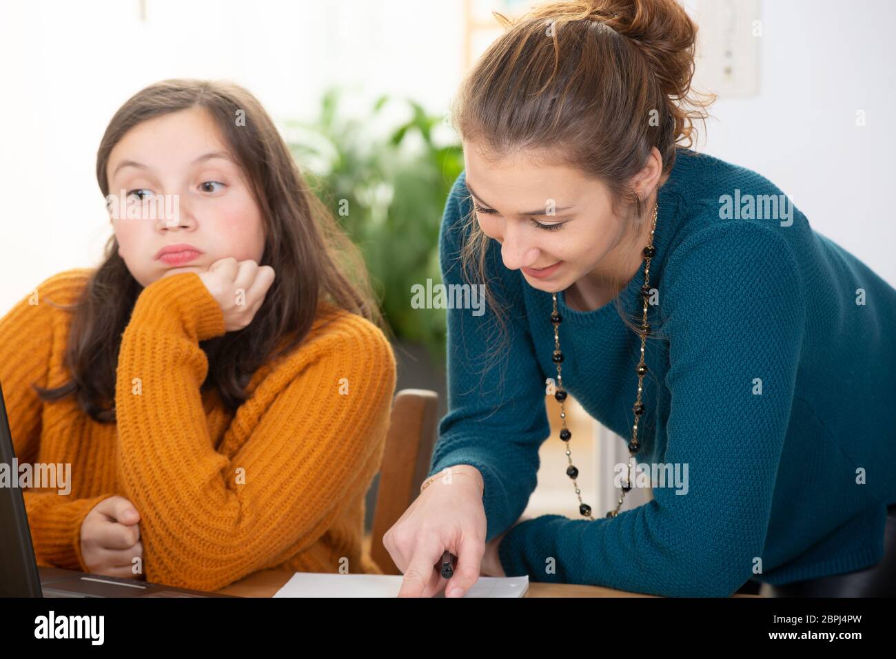 young woman helps a teen girl with homework Stock Photo - Alamy