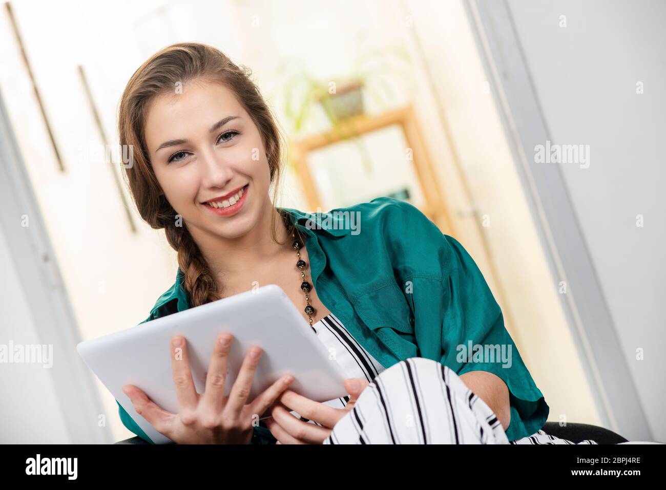 young woman with a braid using a tablet computer Stock Photo - Alamy