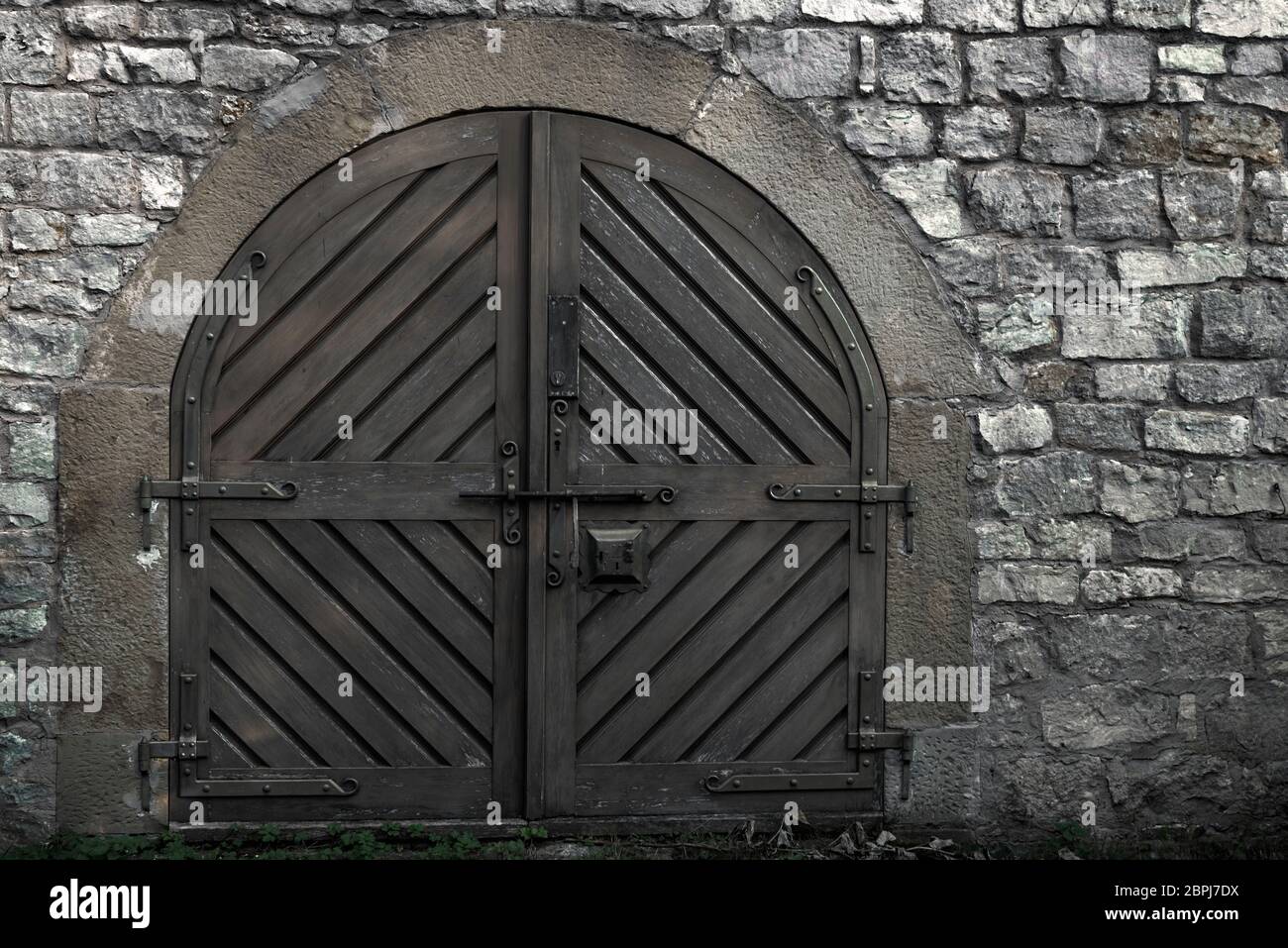 Closed wooden gate, a medieval structure with strong metal hinges and ...