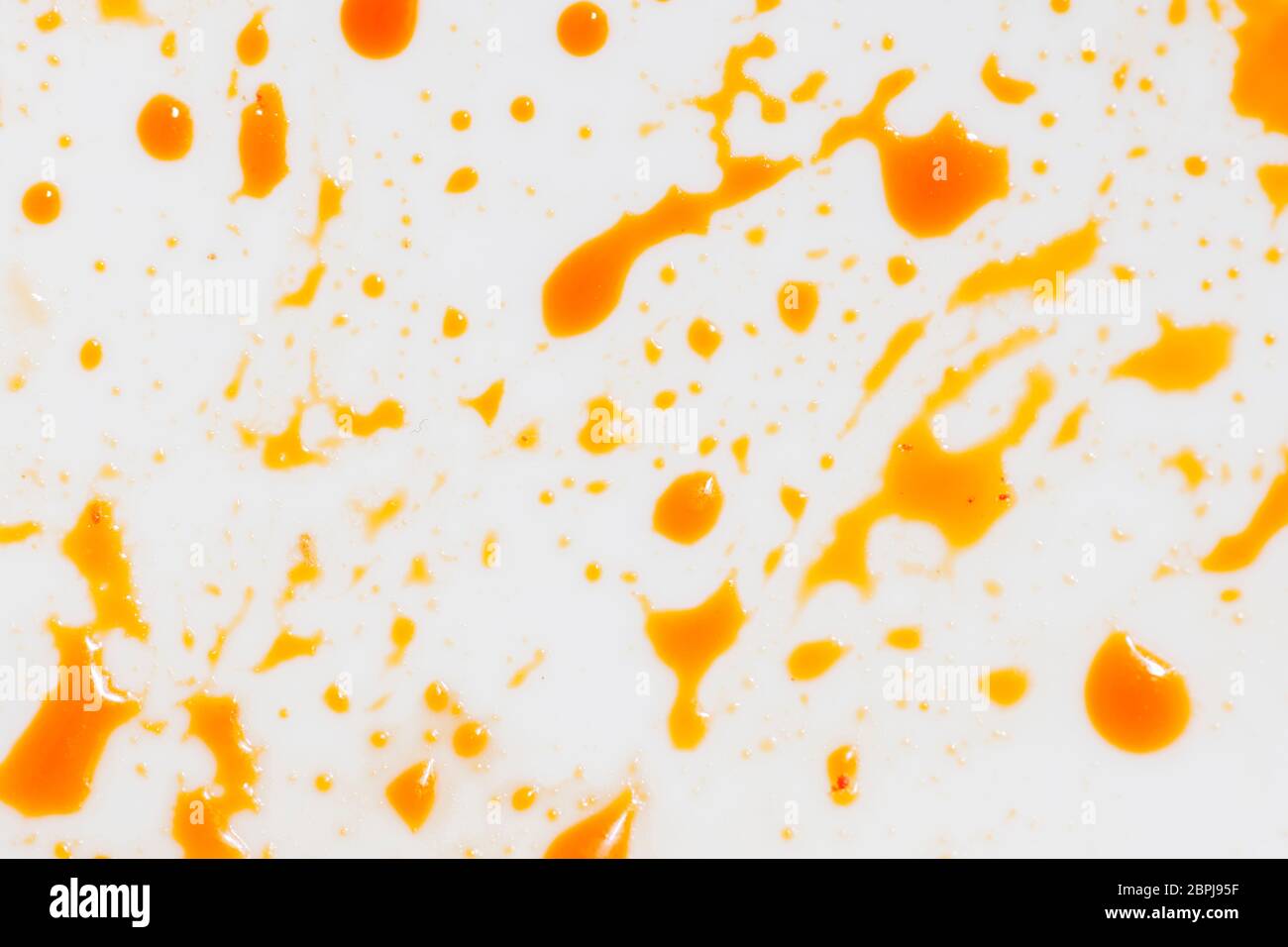 Full-frame view of greasy yellow drops on a white cutting board Stock ...