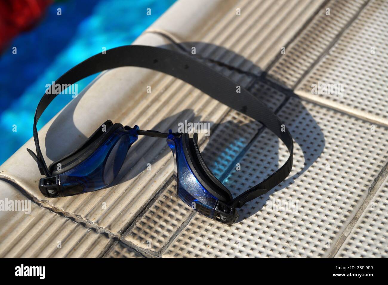 Blue goggles for swimming on a side of the swimming pool Stock Photo ...