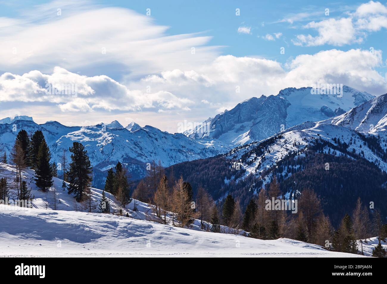 Dolomite mountains covered in snow at daylight. Blue sky with clouds ...