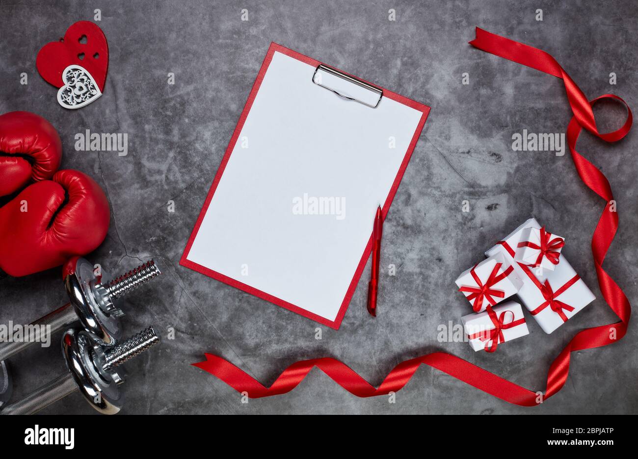 Dumbbells, boxing gloves, gift boxes, red hearts and tablet with blank ...