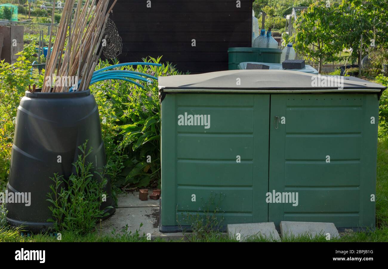 Storage shed, bamboo canes, water bud and compost bin seen on a London ...
