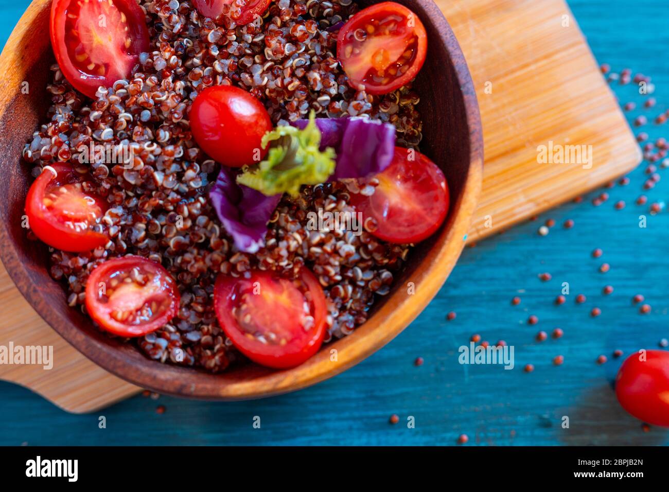 Red quinoa salad with tomato on a rustic table. Superfood and healthy eating concept Stock Photo ...