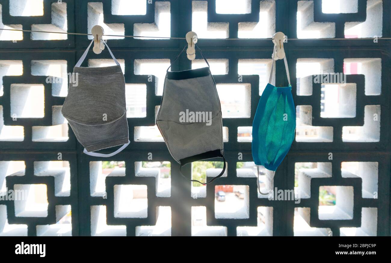 Different Types of protective face masks hanging on a rope. Homemade ...