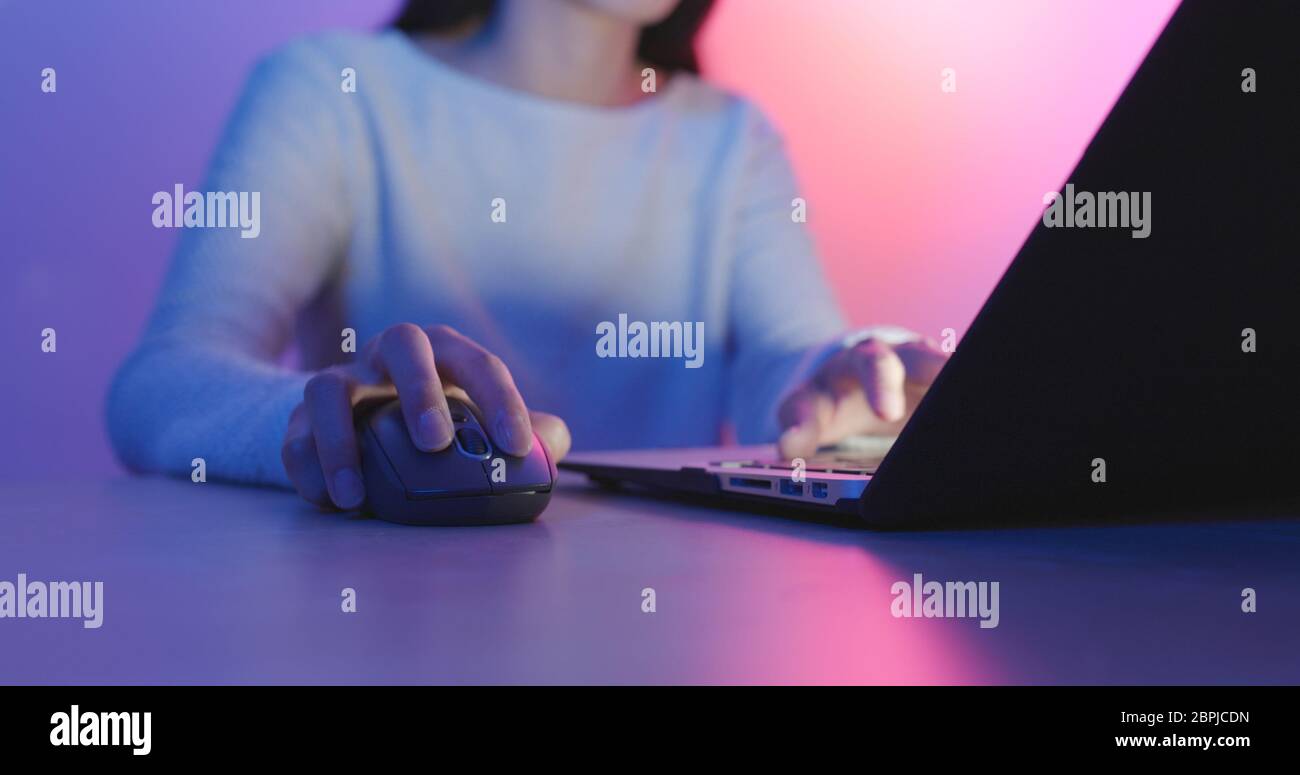 Woman play game on notebook computer with purple and blue light Stock ...