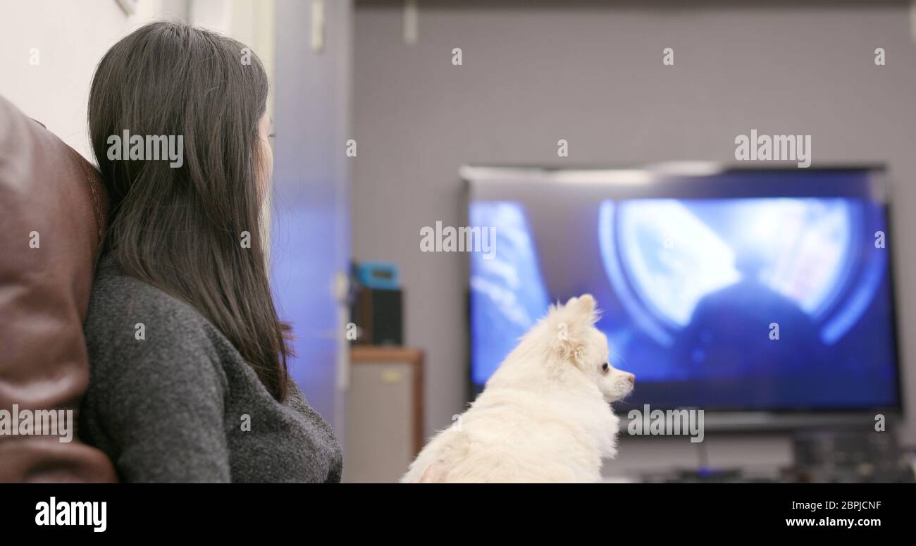 Woman watching tv with her dog Stock Photo - Alamy