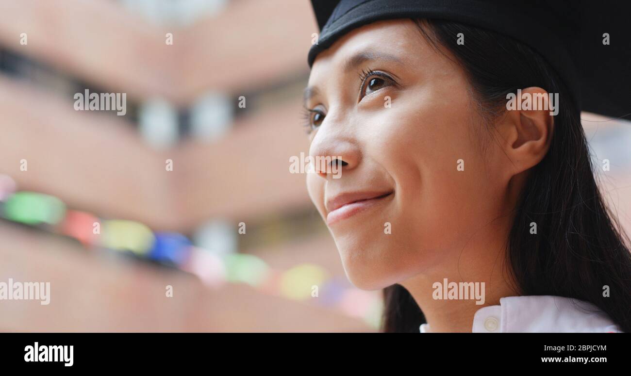 Woman get graduation and think of something Stock Photo - Alamy