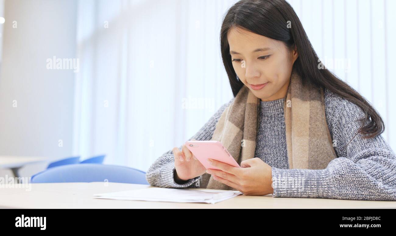 Student using cellphone in library Stock Photo - Alamy