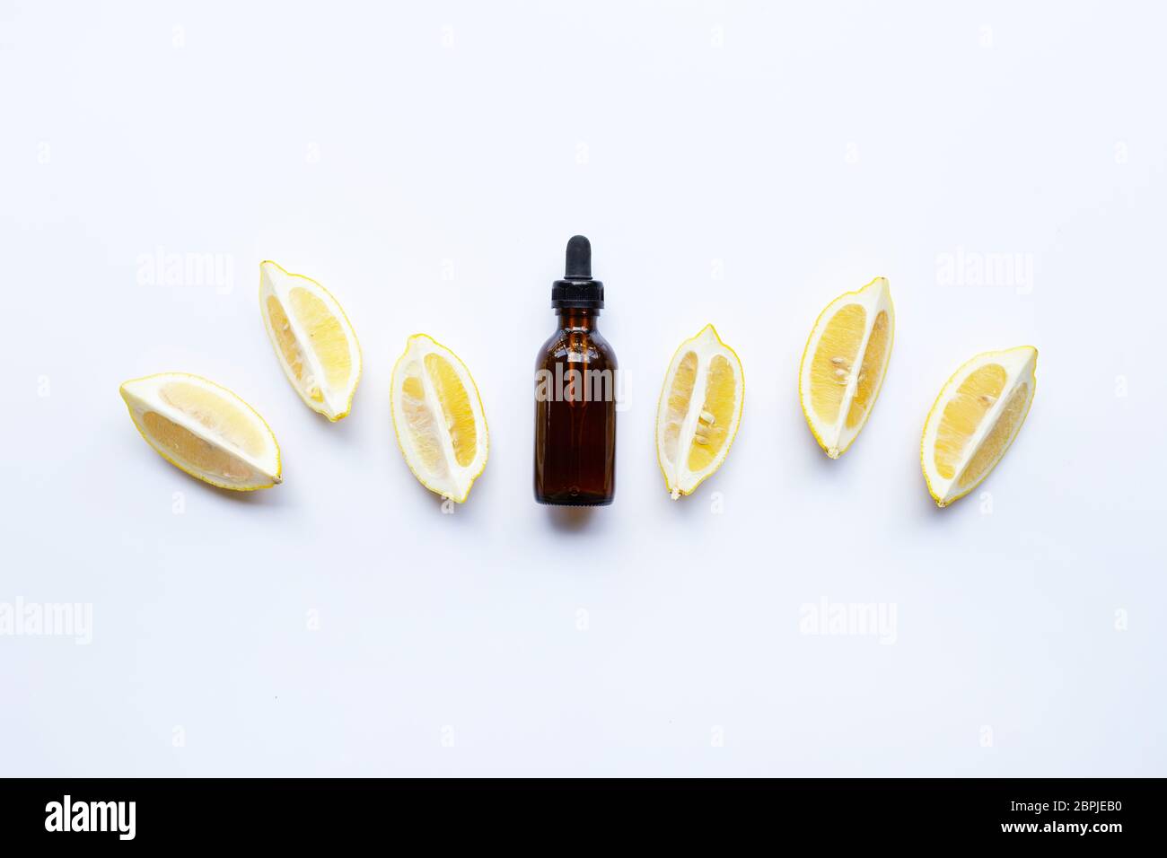 Bottle with lemon essential oil on white background Stock Photo - Alamy