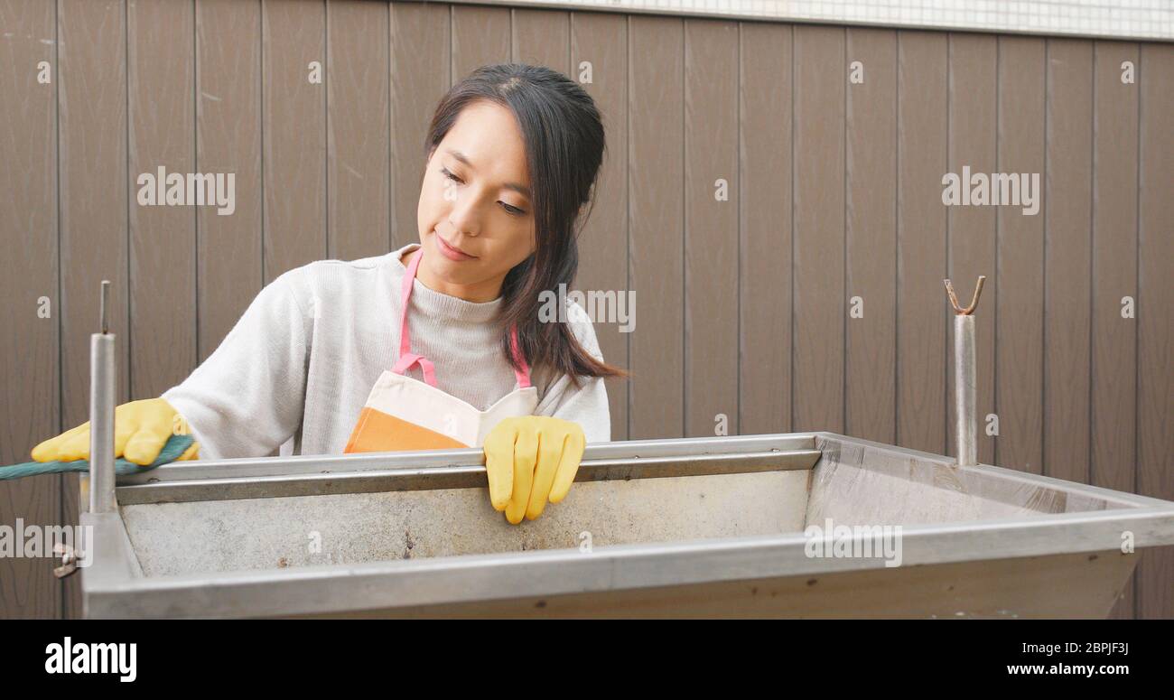 Woman cleaning barbecue stove Stock Photo - Alamy
