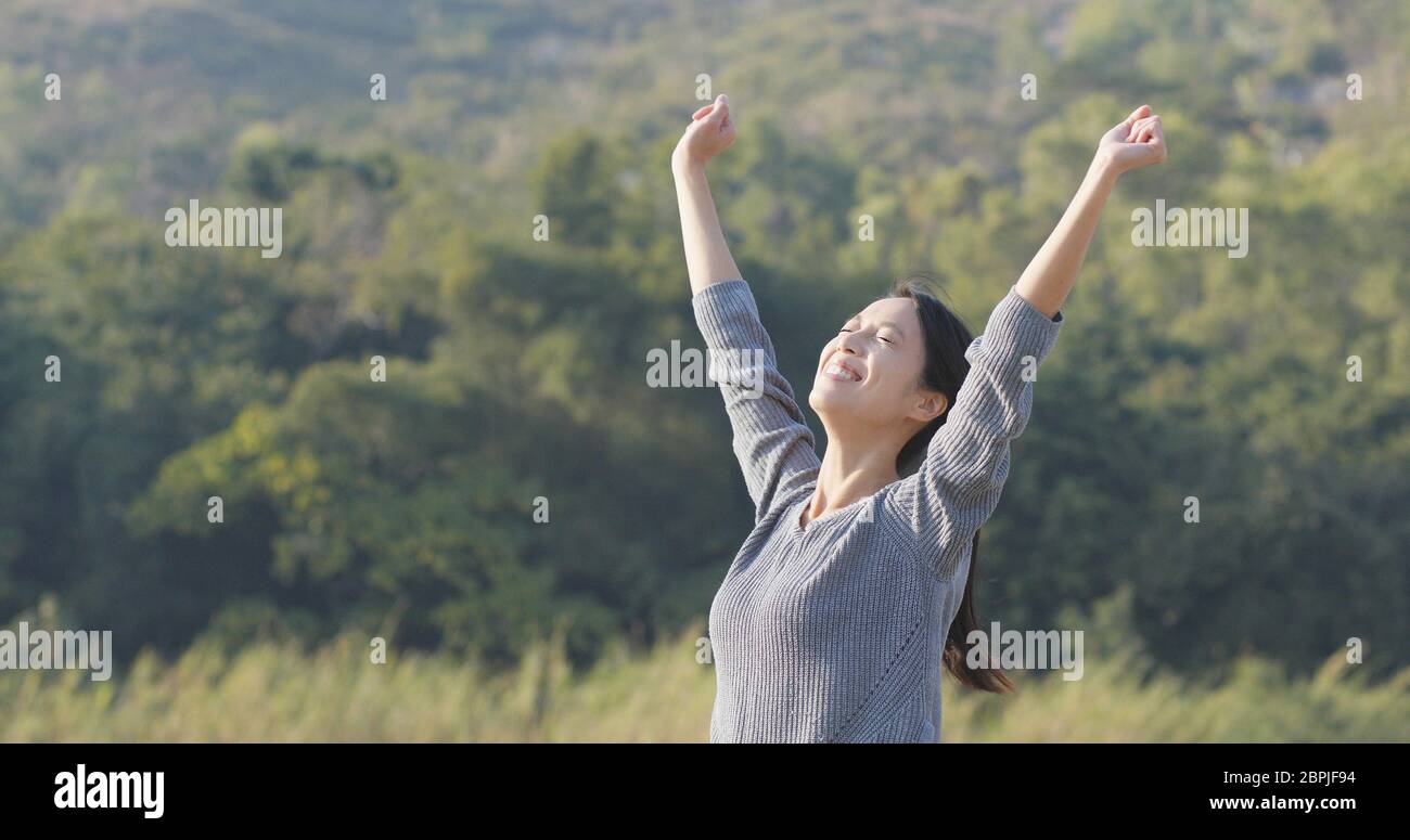 Excited woman raising hand up at outdoor Stock Photo - Alamy