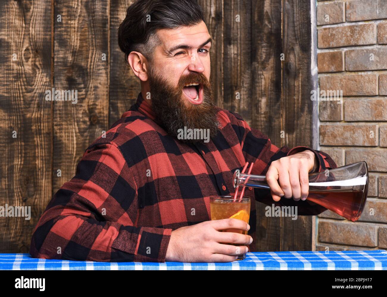 Cheerful bartender concept. Bartender pouring glass and blinking ...