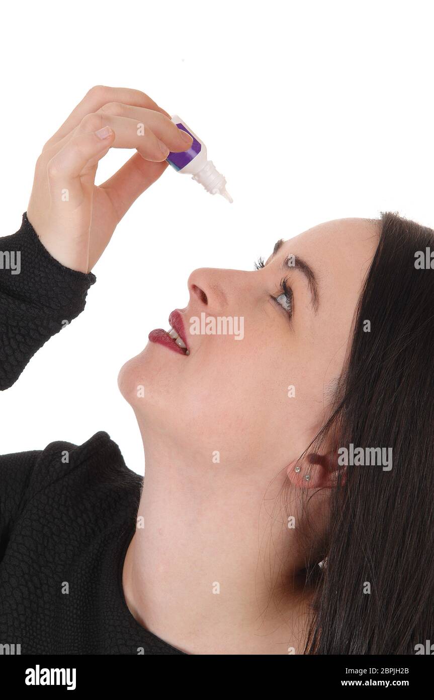 A close up image of a young woman putting eye drops is her dry eye ...