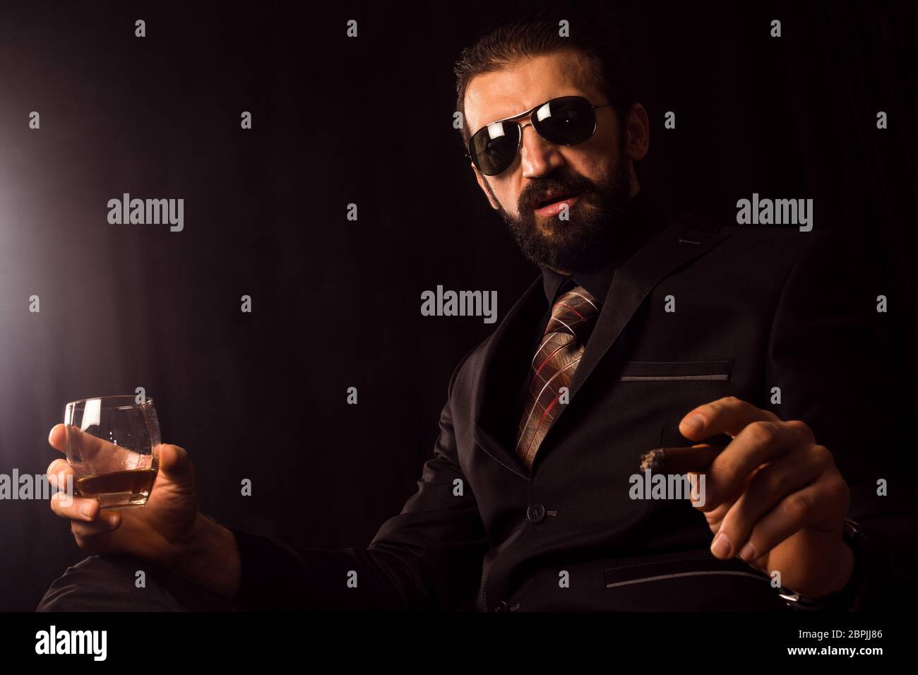 The mafia boss or elegant businessman or gentleman in black suit is ...