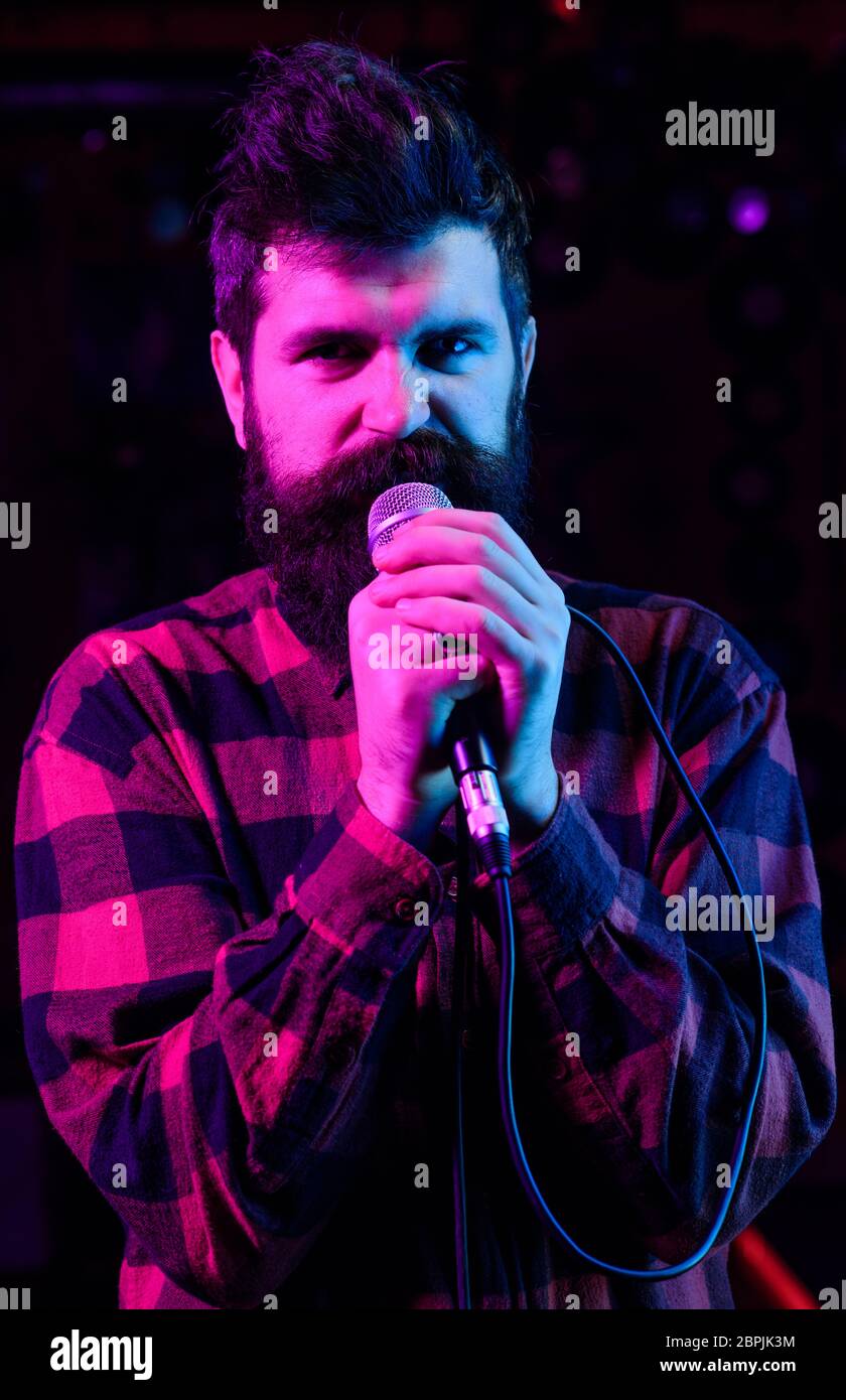 Man with enthusiastic face holds microphone, singing song, black ...