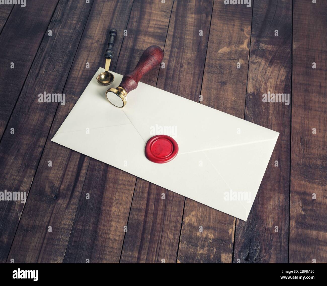 Old letter envelope with red wax seal and stamp on wooden background ...