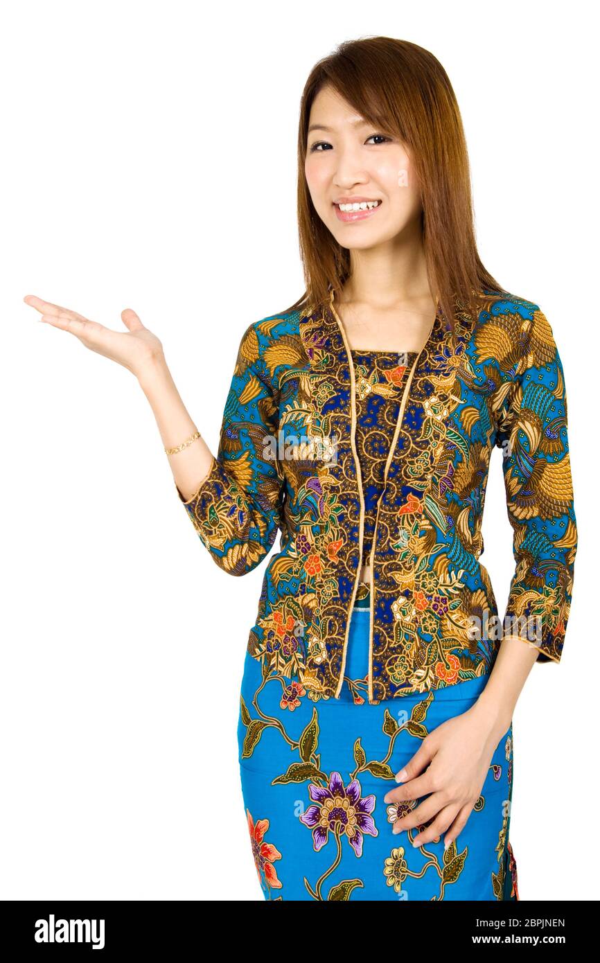 Southeast Asian girl wearing batik kebaya holding hand showing ...