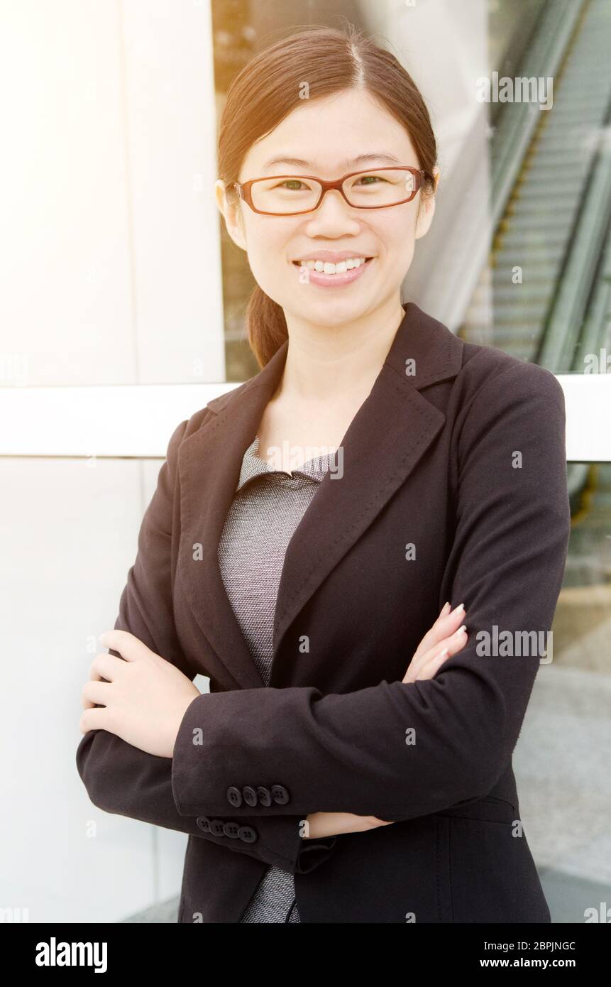 Asian executive arms folded smiles and standing outdoors Stock Photo ...