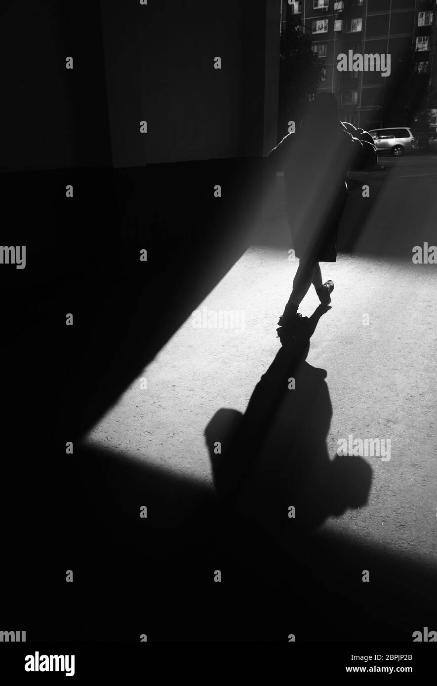 Man walking dropping dramatic shadow in light rays background Stock ...