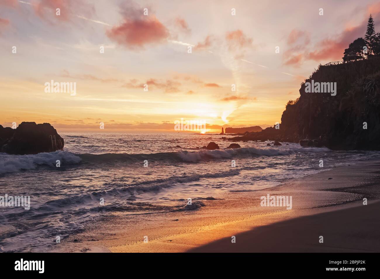 Beautiful sunset on the beach with black volcanic sand Stock Photo - Alamy