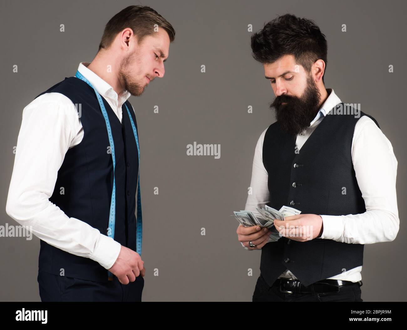 Man with beard pay to macho with measuring tape. Customer, client ...