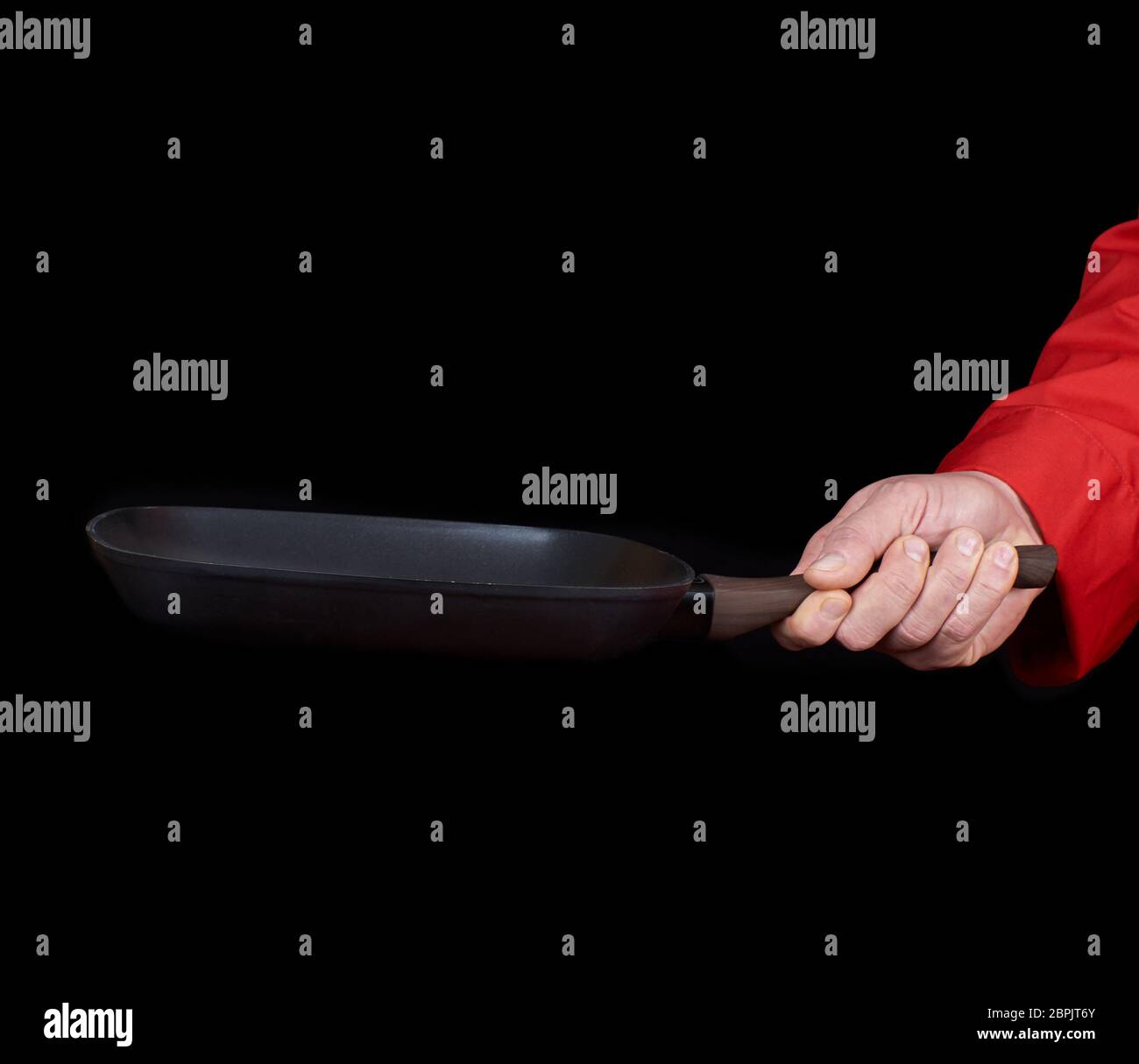 cook in red uniform holding an empty square black frying pan, black ...