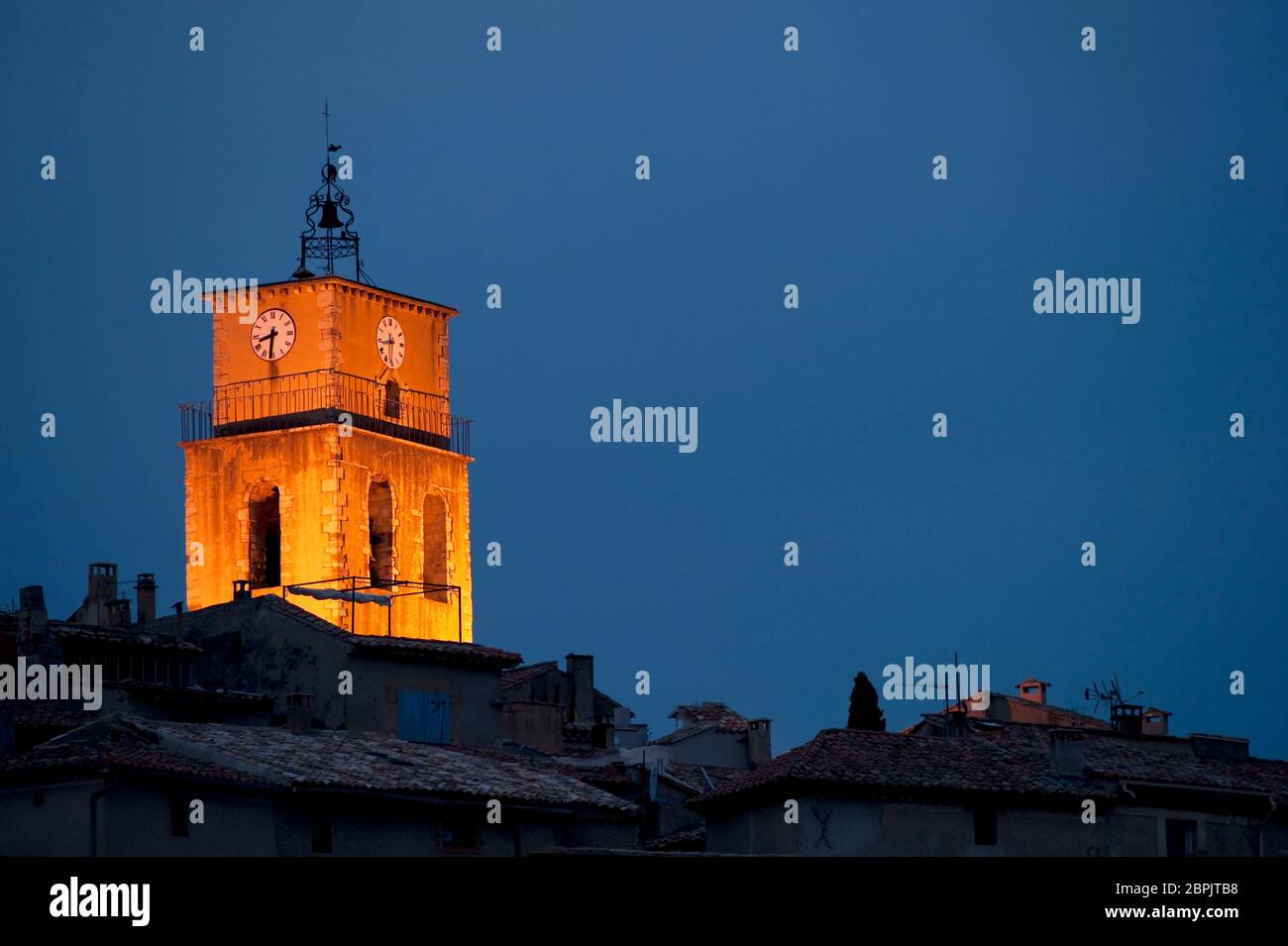 Illuminated Medieval church belltower in the fortified French Provence ...