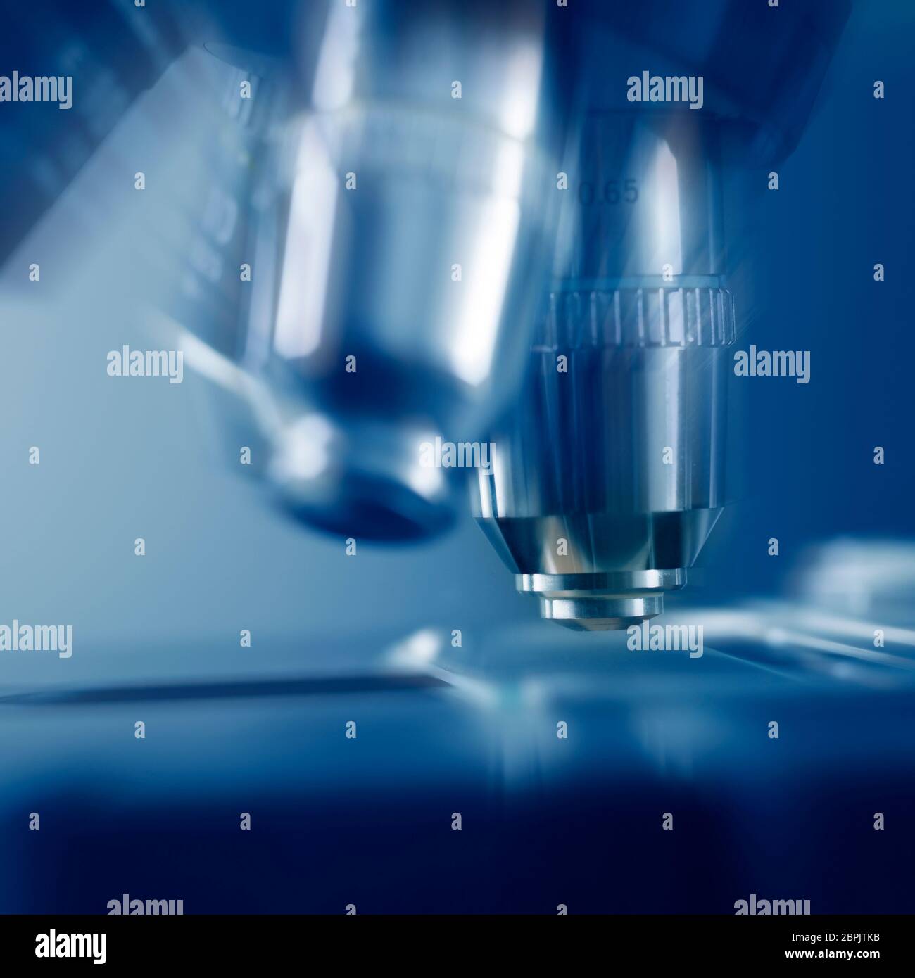 Lenses on the turret of a research microscope with glass slide on stage ...