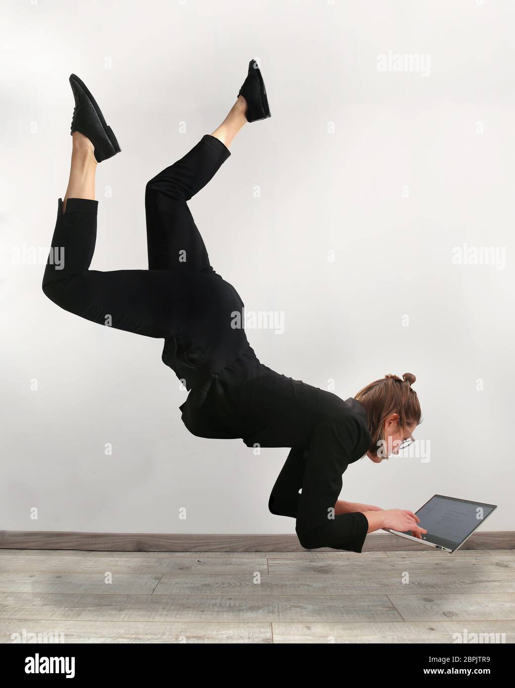 Girl in the black suit levitating in front of the computer in the black ...
