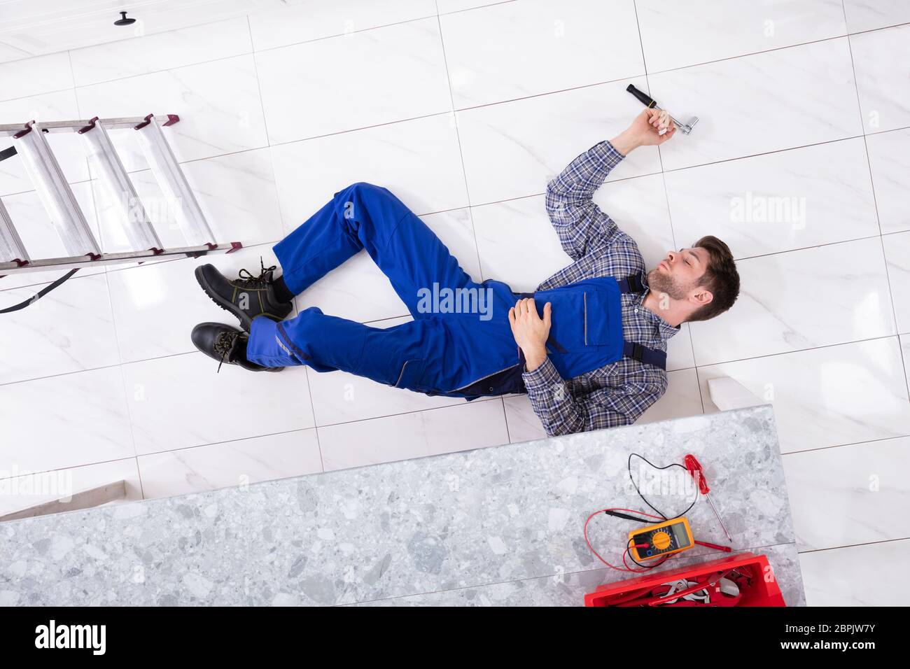 Worker Lying On Floor After Falling From Ladder Stock Photo - Alamy