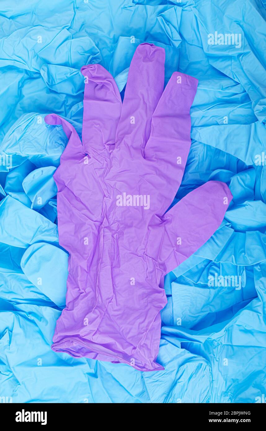 Purple medical glove on blue gloves background Stock Photo - Alamy