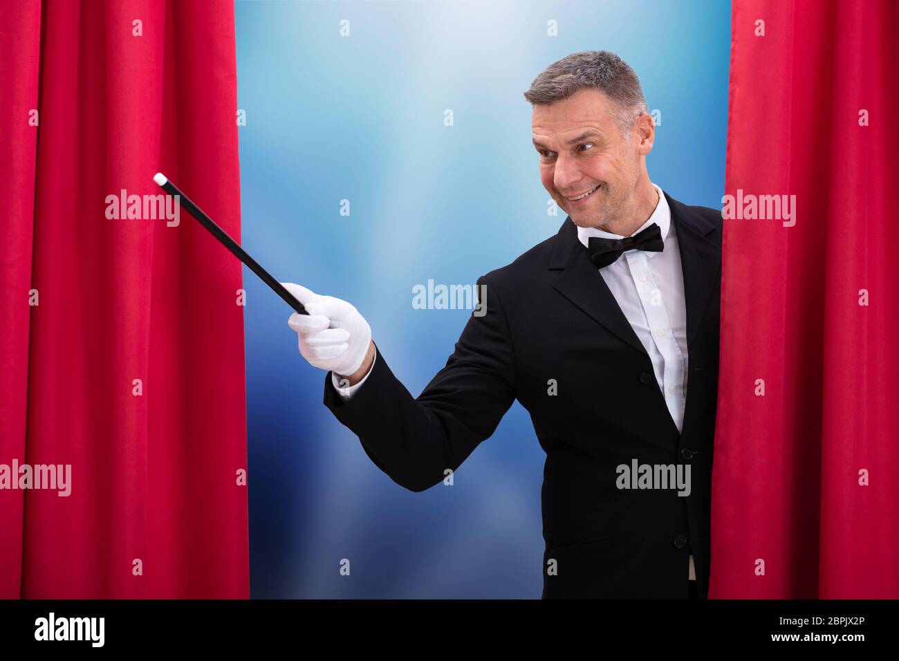 Front View Of Smiling Magician Holding Magic Wand Stock Photo - Alamy