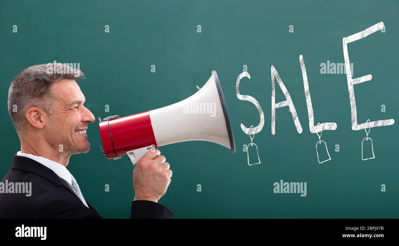 Side View Of Businessman Shouting Through Megaphone Advertising Sale ...