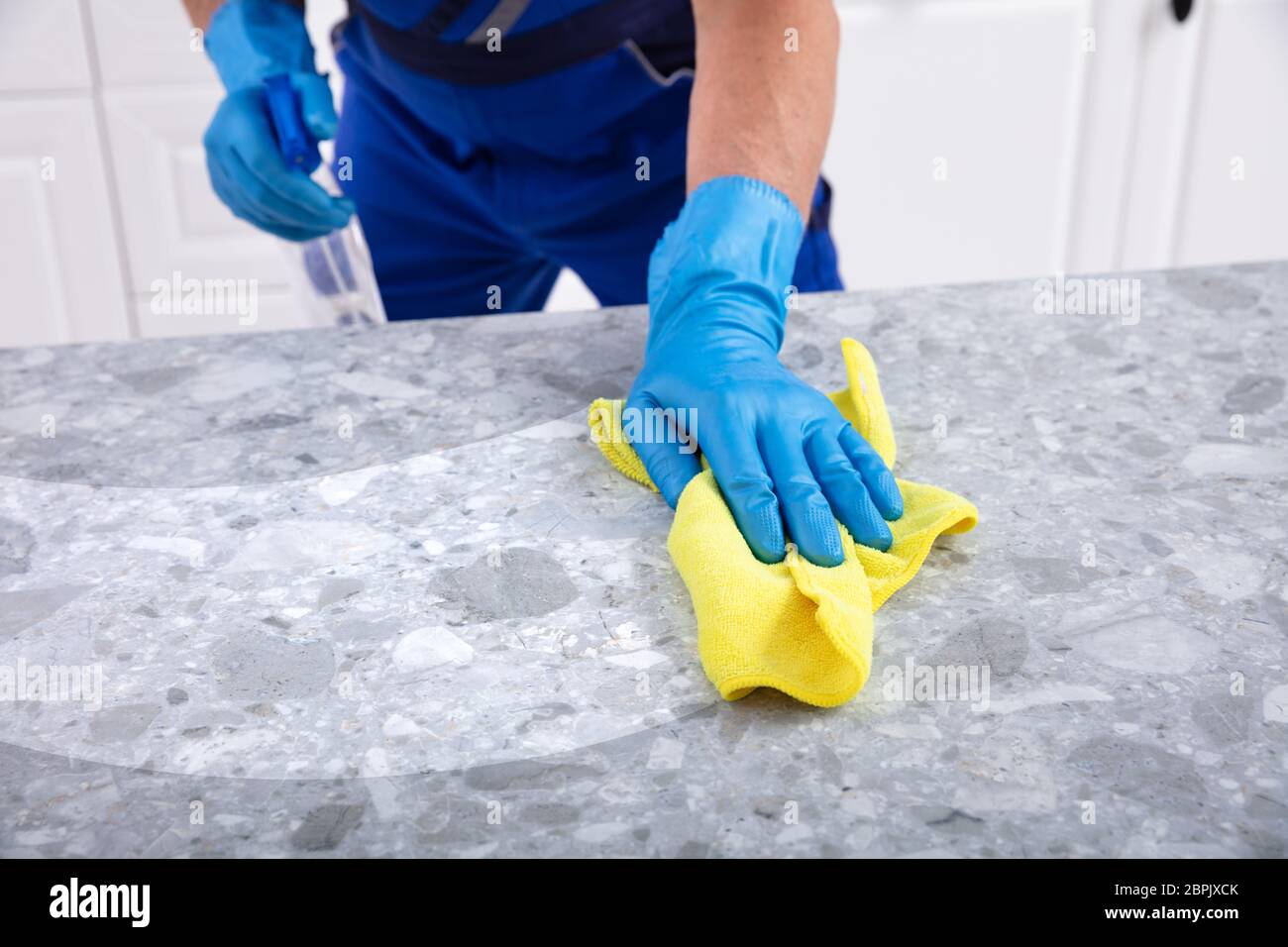 Mid Section Of A Male Janitor Cleaning Dirty Kitchen Counter With Spray ...