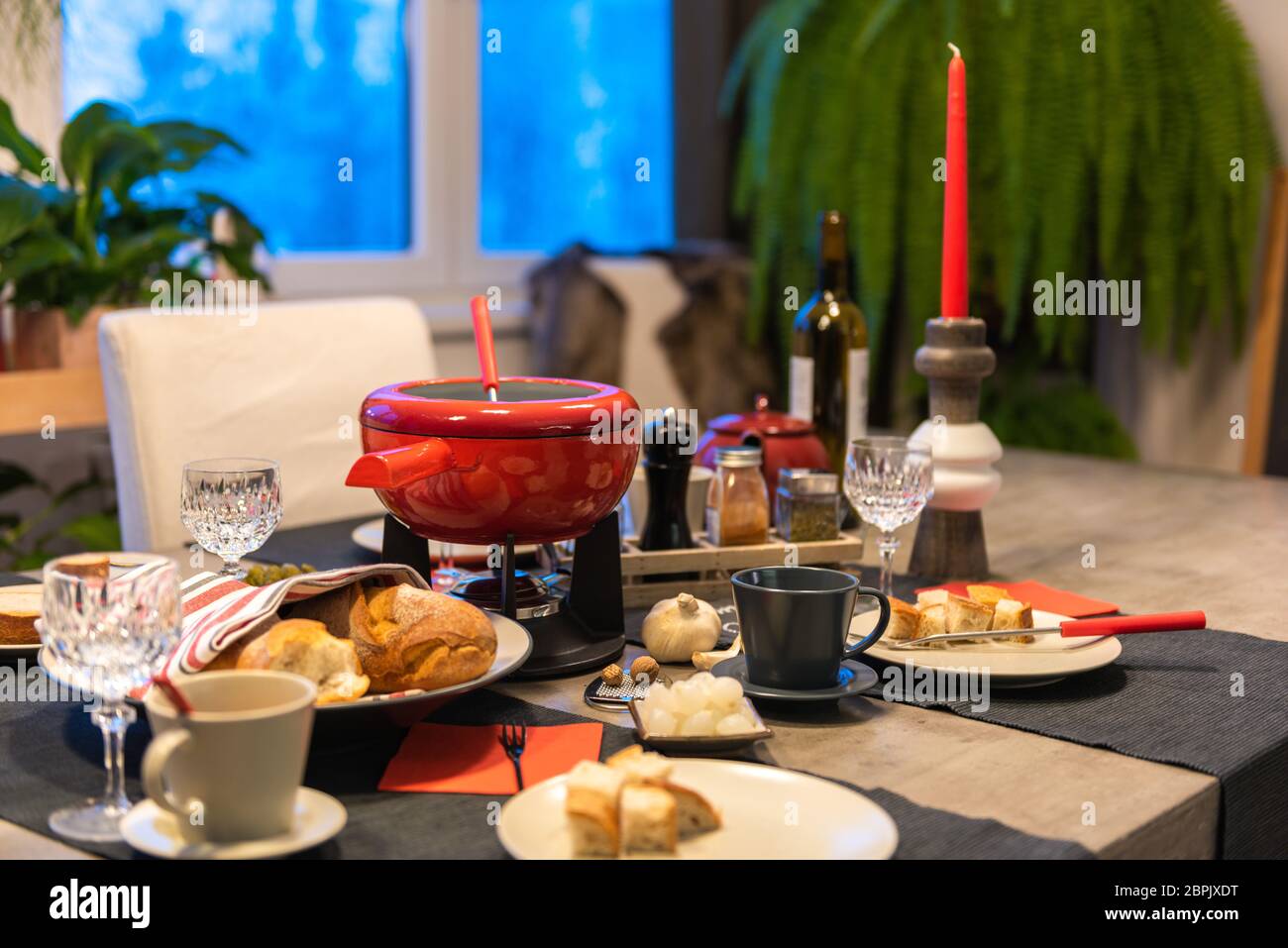 Traditional swiss cheese fondue in a red pot on concrete dining table ...
