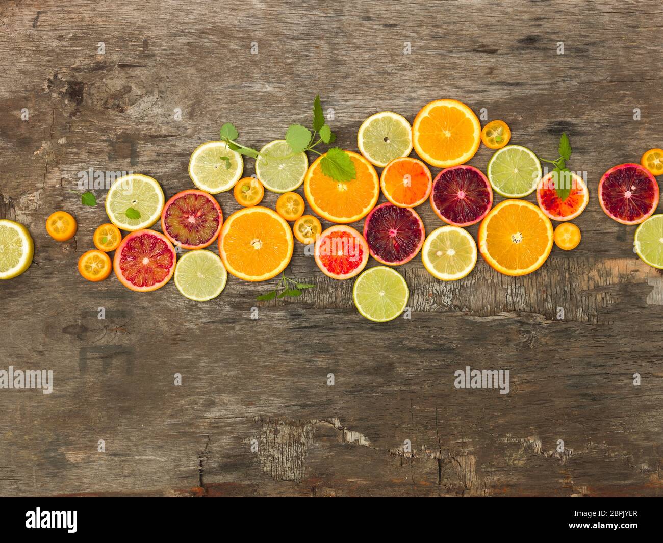 many different juicy and healthy citrus fruits lie together on an old ...