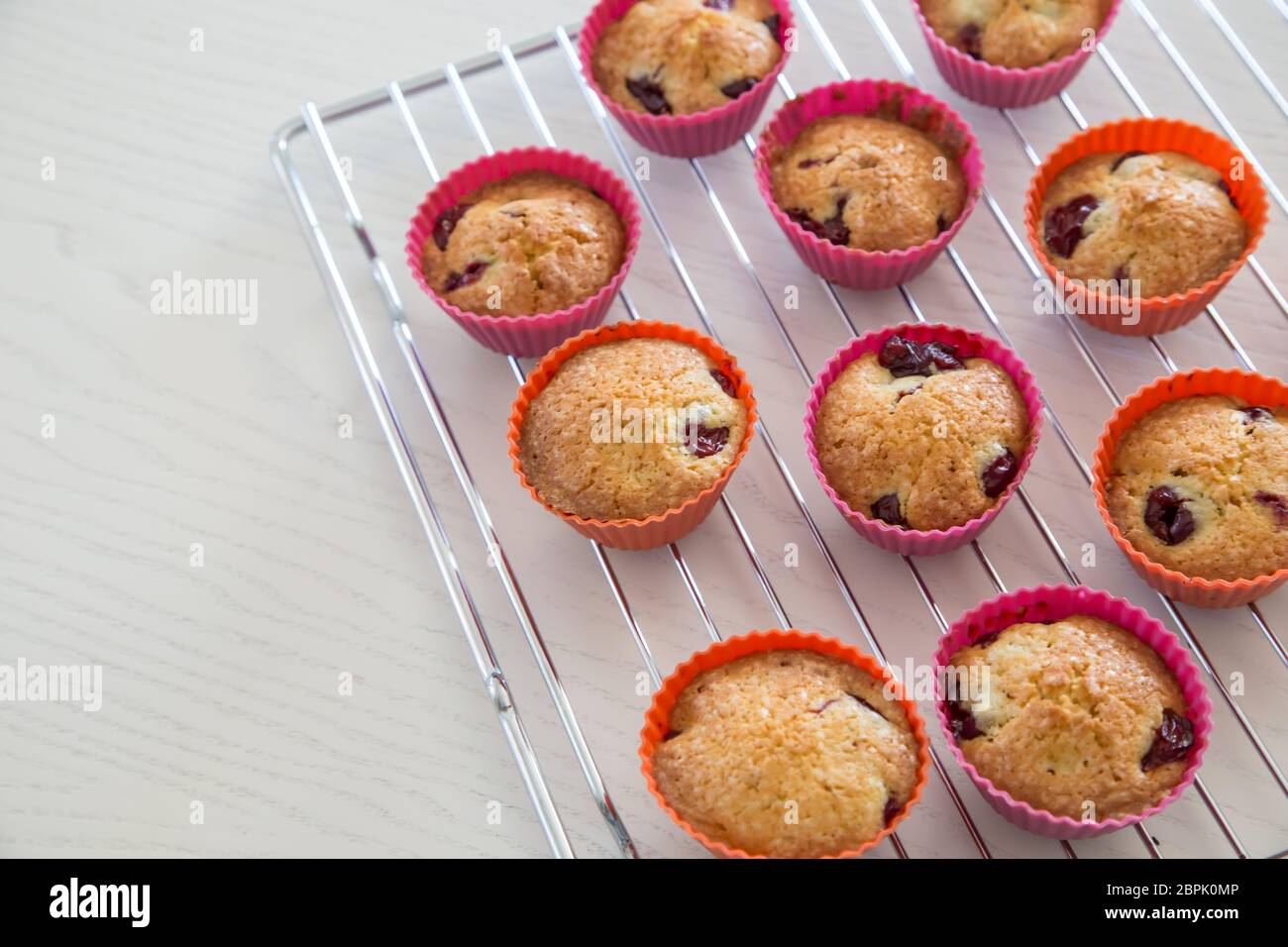 homemade cupcakes with cherry, muffins on a wire rack on a white table ...