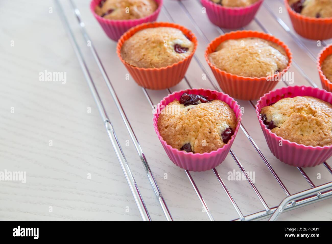 homemade cupcakes with cherry, muffins on a wire rack on a white table ...