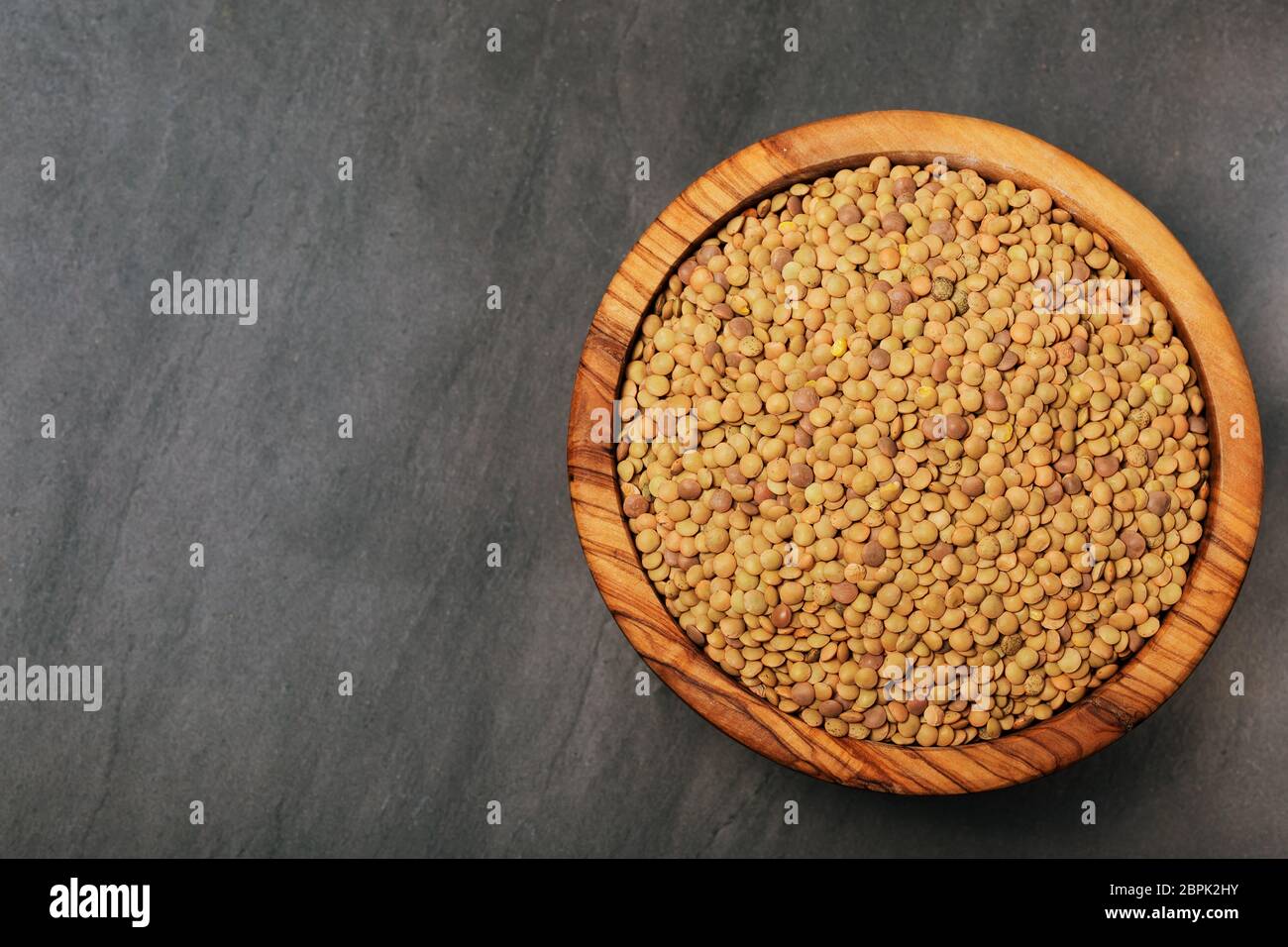 Raw lentils on balck stone background. Healthy vegetarian food concept ...