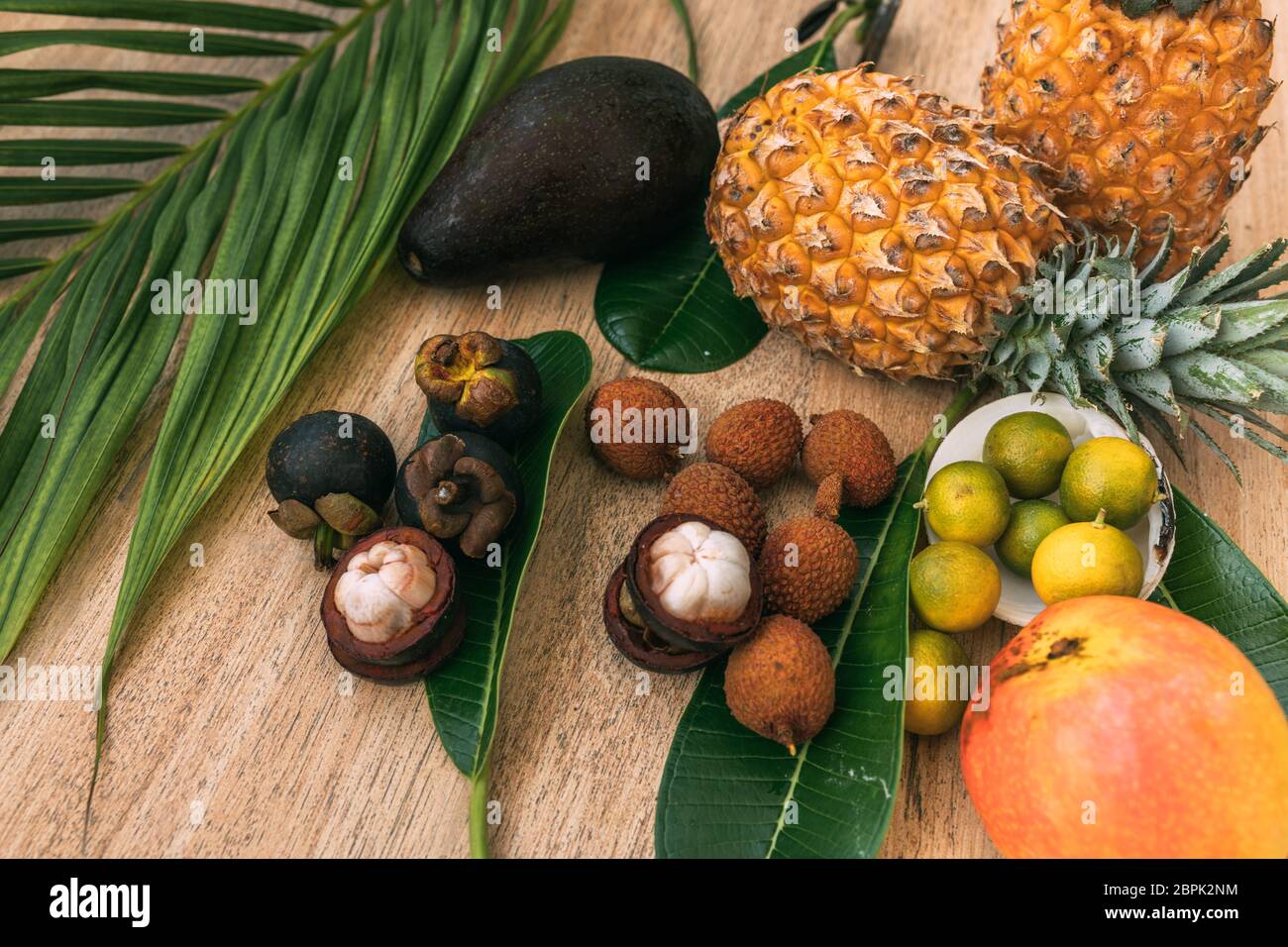 top view, Mix of Exotic fruits and palm leaf on a brown background ...