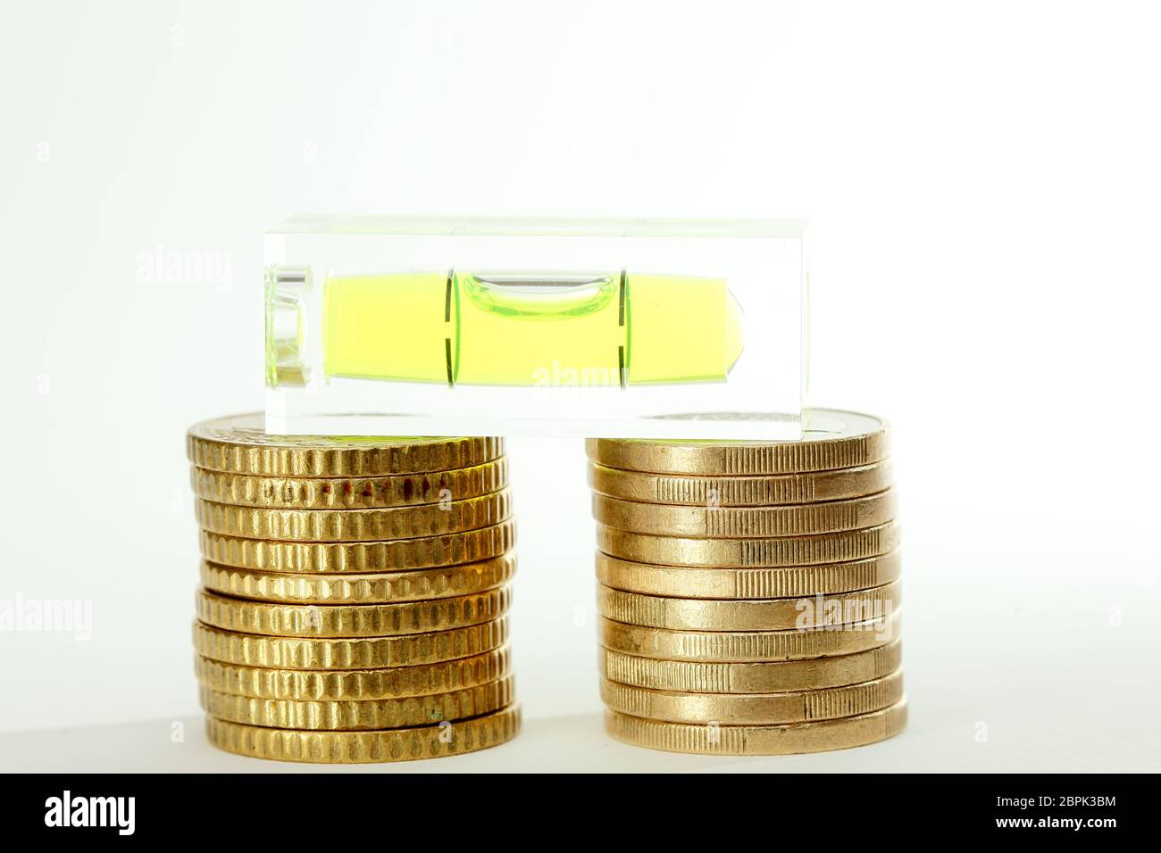 finance in balance symbol with coin stacks and leveler Stock Photo - Alamy