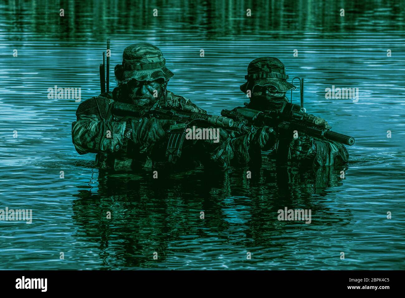 Pair of soldiers in action during river raid in the jungle in the night ...