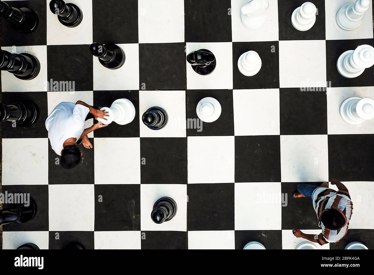 People playing giant chess in a backyard of a village house.Chess is a ...